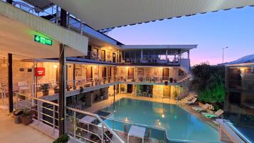 Um hotel com vários níveis, piscina, área de estar ao ar livre e escadaria que dá acesso aos andares superiores.
