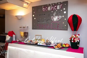 Disposição de buffet de café da manhã com uma placa decorativa, um gnomo e uma decoração de balão de ar quente.