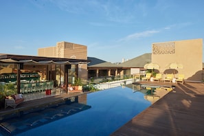 Um resort com piscina, área de estar ao ar livre e bar.