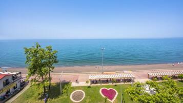 Um hotel à beira-mar com vista para o mar, área de estar externa e um canteiro de flores em formato de coração.