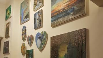Paredes decoradas com diversas obras de arte, incluindo pinturas e corações.