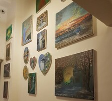 Paredes decoradas com diversas obras de arte, incluindo pinturas e corações.