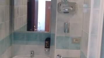 Casa de banho com lavatório, espelho e porta-toalhas.