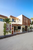 Um hotel com fachada moderna, entrada coberta e uma placa com a inscrição 'HOTEL SIESTA'.