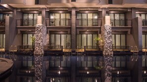 Um hotel com uma grande piscina interna, várias varandas e pilares de pedra.