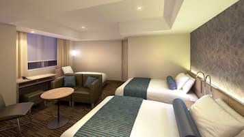 Quarto de hotel com duas camas, uma escrivaninha, uma cadeira e uma janela.