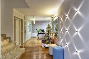 Um interior moderno com escada, árvore de Natal e parede acolchoada.