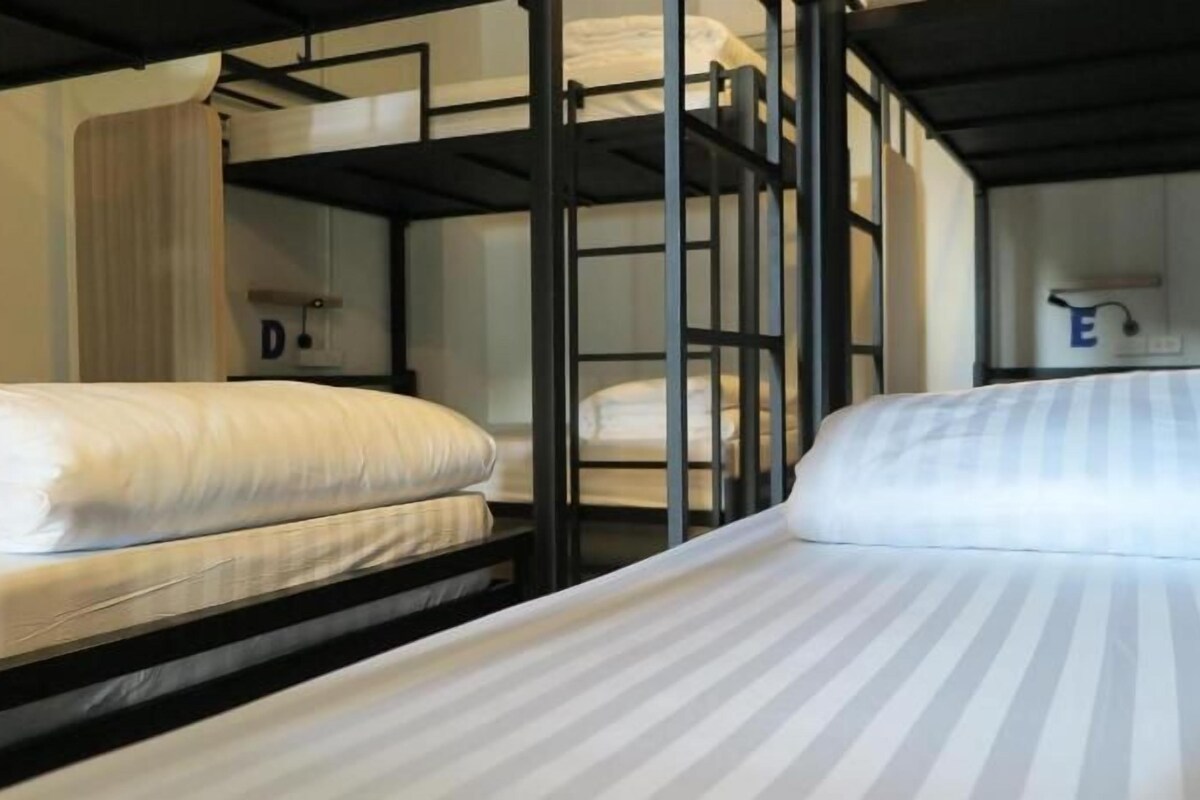 Quarto com beliche à esquerda e cama de solteiro à direita.