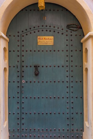 Uma porta grande e ornamentada com uma placa em cima.