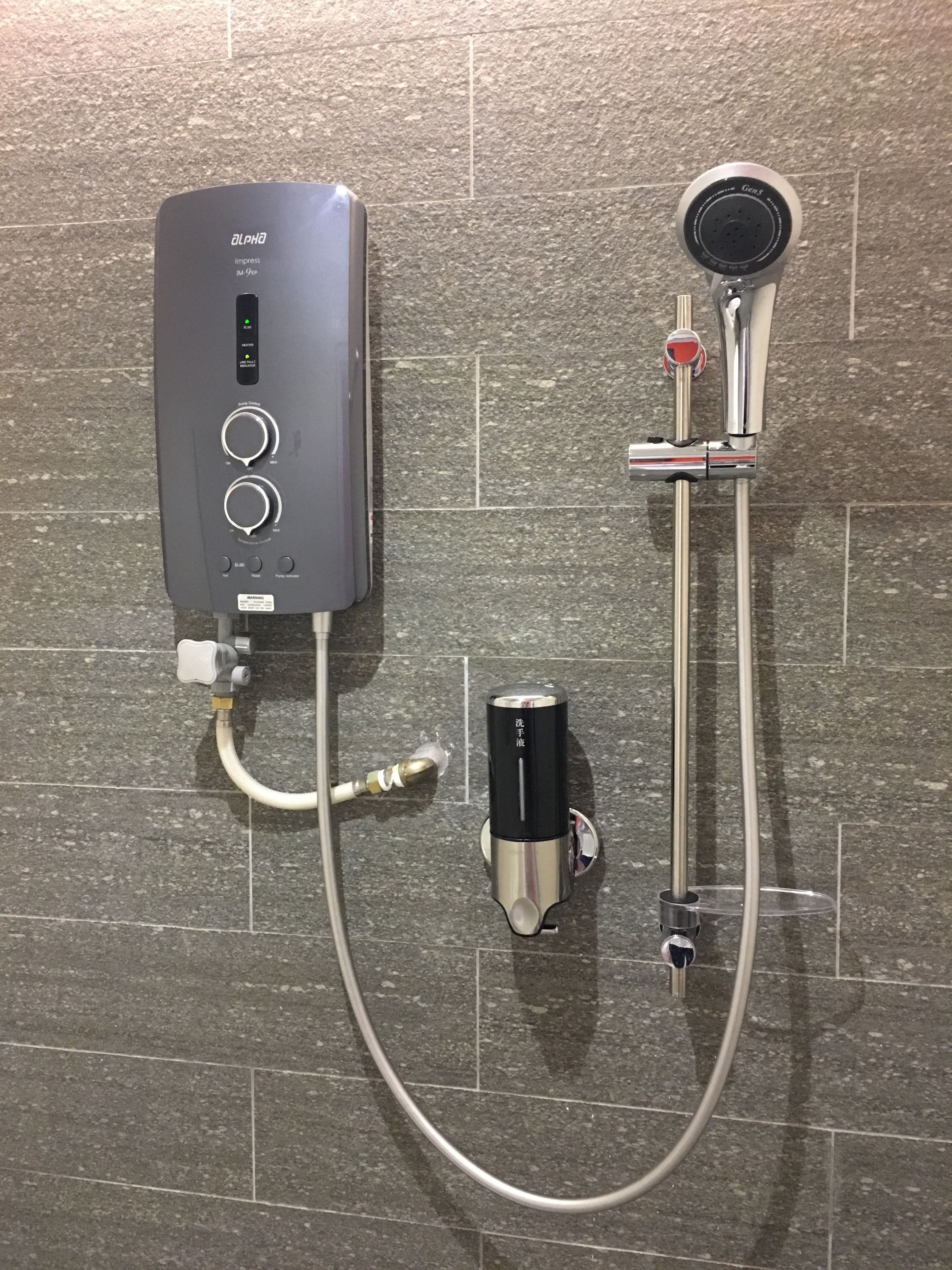 Um chuveiro fixado na parede, com painel de controle, chuveiro manual e massageador manual.