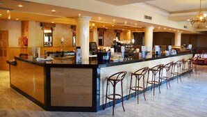 Uma área de bar com um balcão comprido, vários bancos e uma máquina de café.