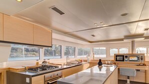 Cozinha moderna com ilha central, forno embutido e grandes janelas com vista para o exterior.