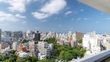 Paisagem urbana com diversos edifícios, incluindo apartamentos altos e construções comerciais, sob um céu azul e limpo.