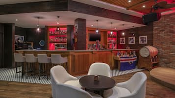 Uma área de bar com teto de madeira, banquetas, uma mesa redonda e balcão com garrafas.