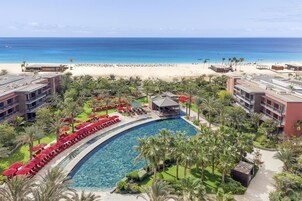 Um resort com piscina, praia e vista para o mar.