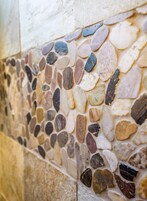 Paredes com mosaico de pedras coloridas e de formatos variados.