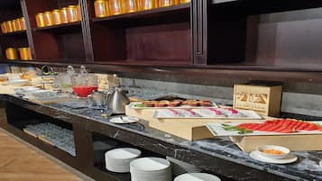 Disposição de buffet com diversos alimentos e acompanhamentos.