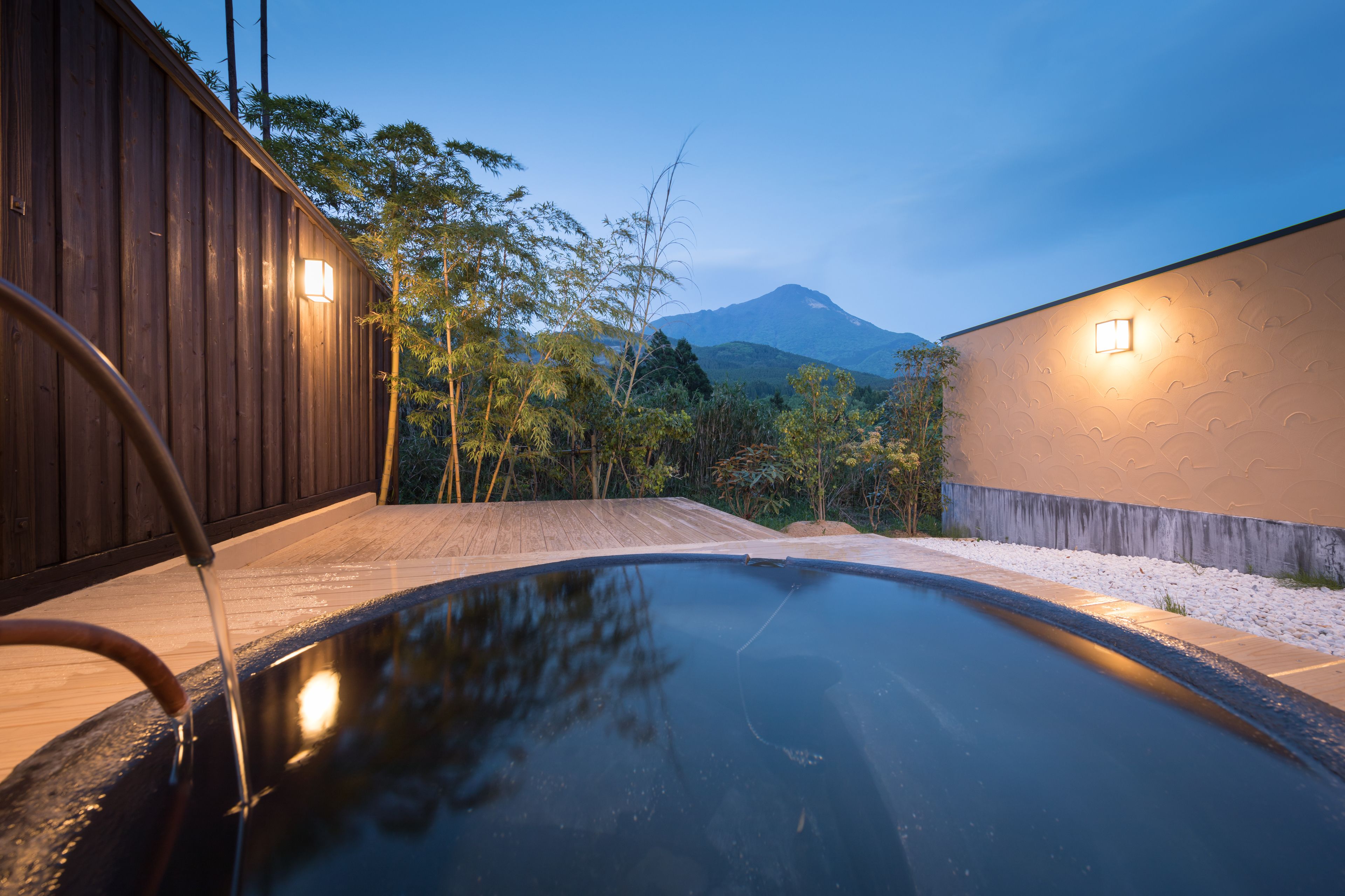 Uma banheira de hidromassagem com deck de madeira e vista para uma montanha.