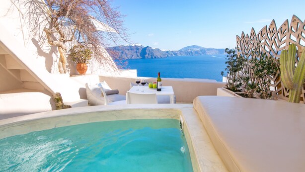 Área da piscina com vista para o mar e montanhas.