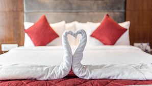 Quarto de hotel com cama e toalhas dispostas em formato de coração.