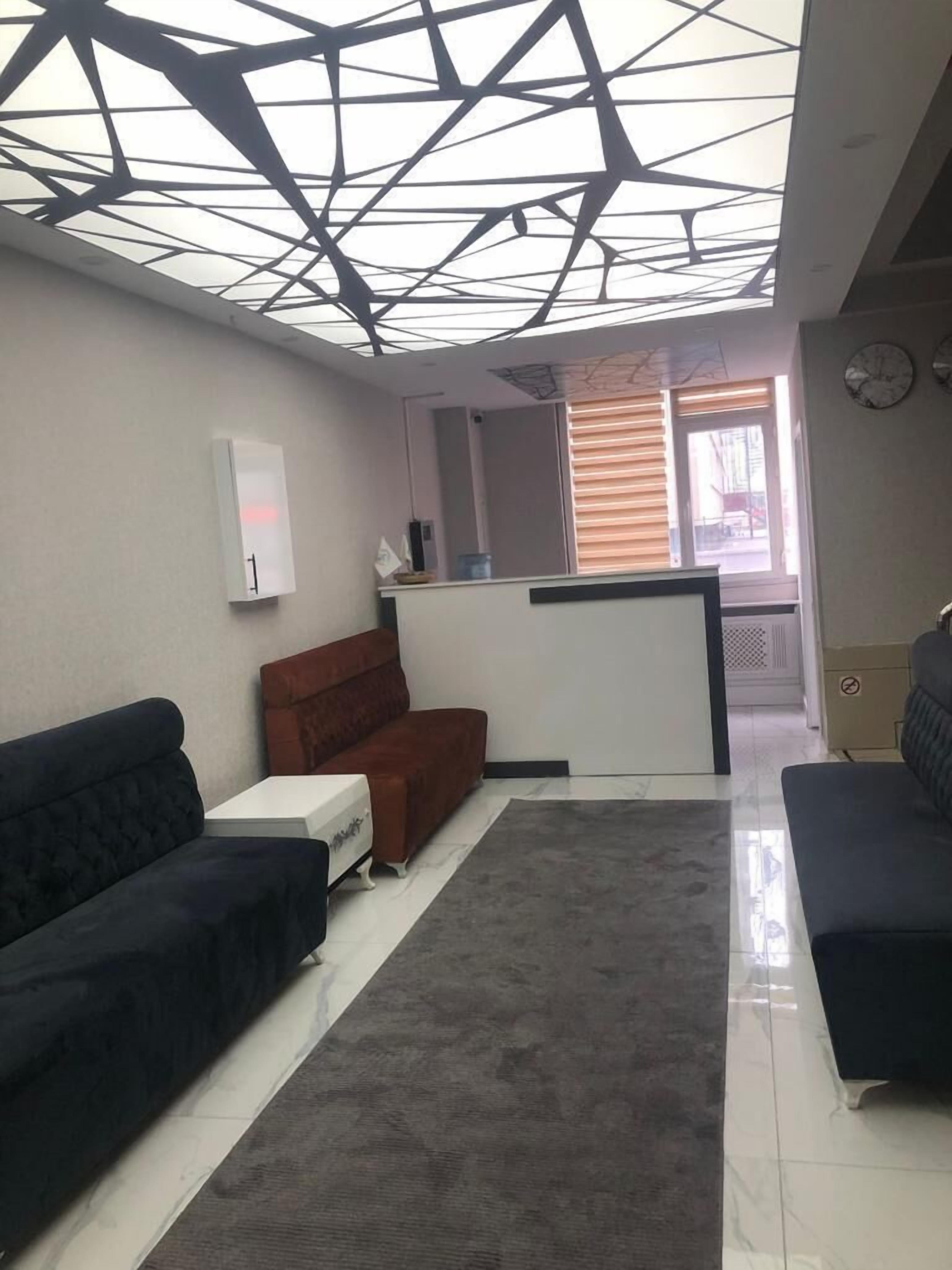 Uma sala de estar moderna com teto de vidro, um balcão de recepção e dois sofás.