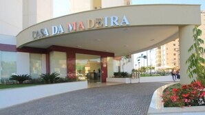A entrada da Casa da Madeira, com um telhado curvo e fachada de vidro.