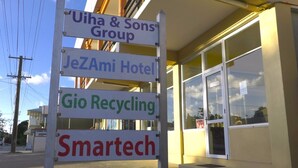 Uma placa com os nomes 'Ulha & Sons Group', 'JeZAMi Hotel', 'Gio Recycling' e 'Smartech'.