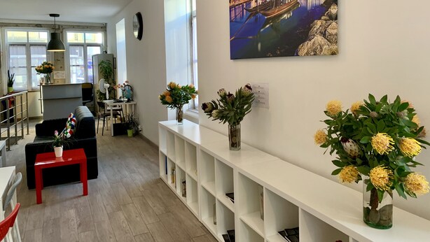 Uma sala de estar espaçosa com design moderno, destacando um grande janelão, um console branco com vasos decorativos e um espaço de estar aconchegante.