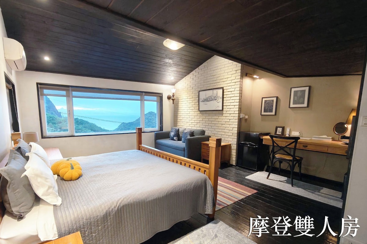 Quarto duplo moderno com cama, escrivaninha e vista para o exterior.