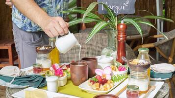Uma mesa com diversos alimentos e uma pessoa servindo um líquido.