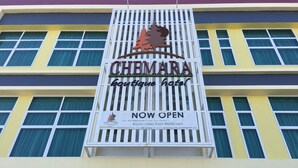 Placa de hotel com logotipo de árvore e o nome 'CHEMARA Boutique Hotel'.