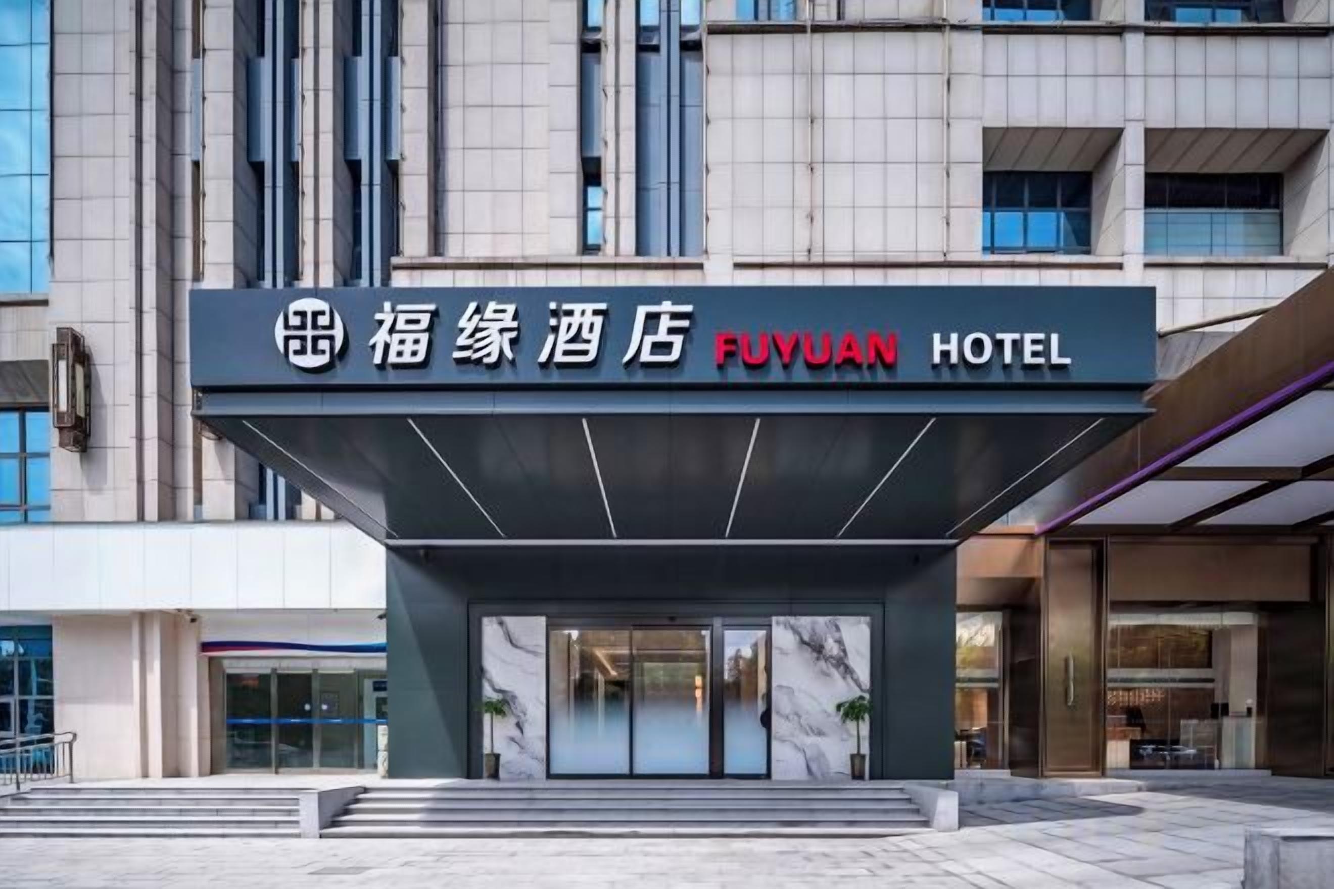 Entrada de hotel com placa indicando ser o Fuyuan Hotel.