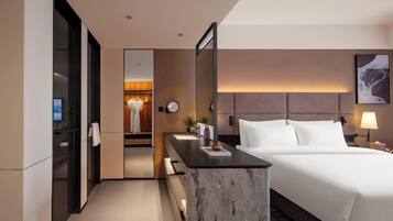 Quarto de hotel moderno com cama, mesa de cabeceira e espelho.