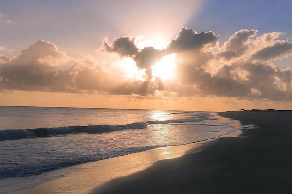 Na praia, areia branca, barracas de praia de cortesia
