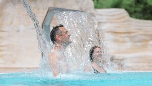 Uma pessoa em uma piscina com água espirrando ao redor.