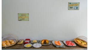 Buffet de café da manhã com diversos alimentos e dois letreiros na parede.