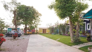 Rua residencial com casas, calçada pavimentada e carros estacionados.