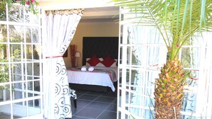 Um quarto com cama, almofadas e cortina.