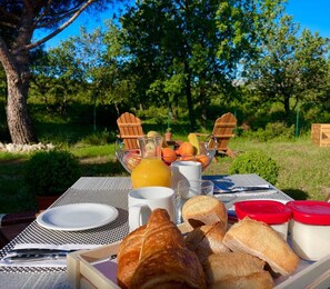 Uma área de piquenique montada com mesa, comida e bebidas em um parque.