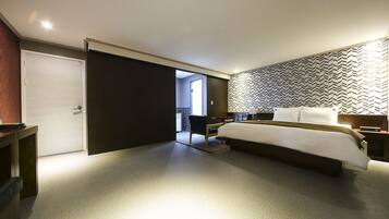 Quarto de hotel moderno com uma cama grande, uma escrivaninha e um guarda-roupa.