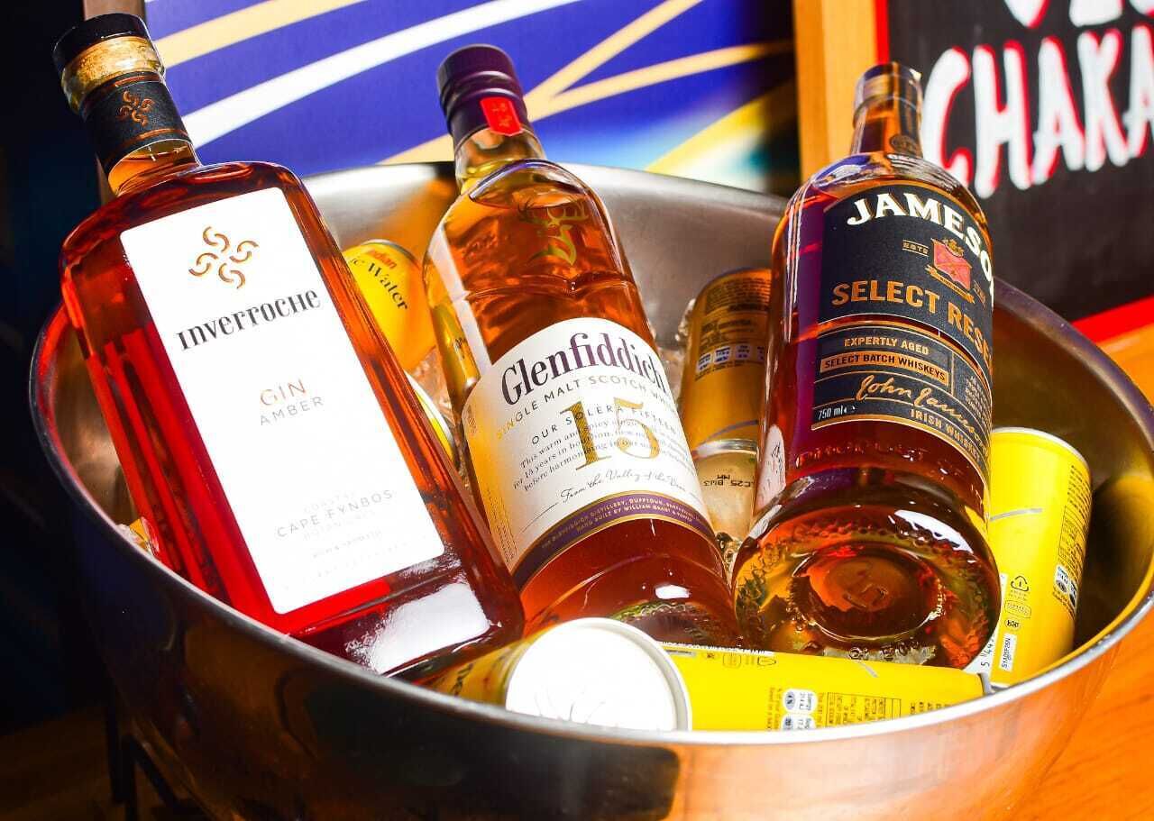 Um balde com diversas garrafas de álcool, incluindo Glenfiddich e Jameson Select Reserve.