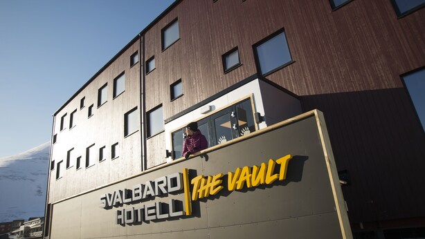 Um edifício com uma placa que diz "Valbard Hotel" e "The Vault".