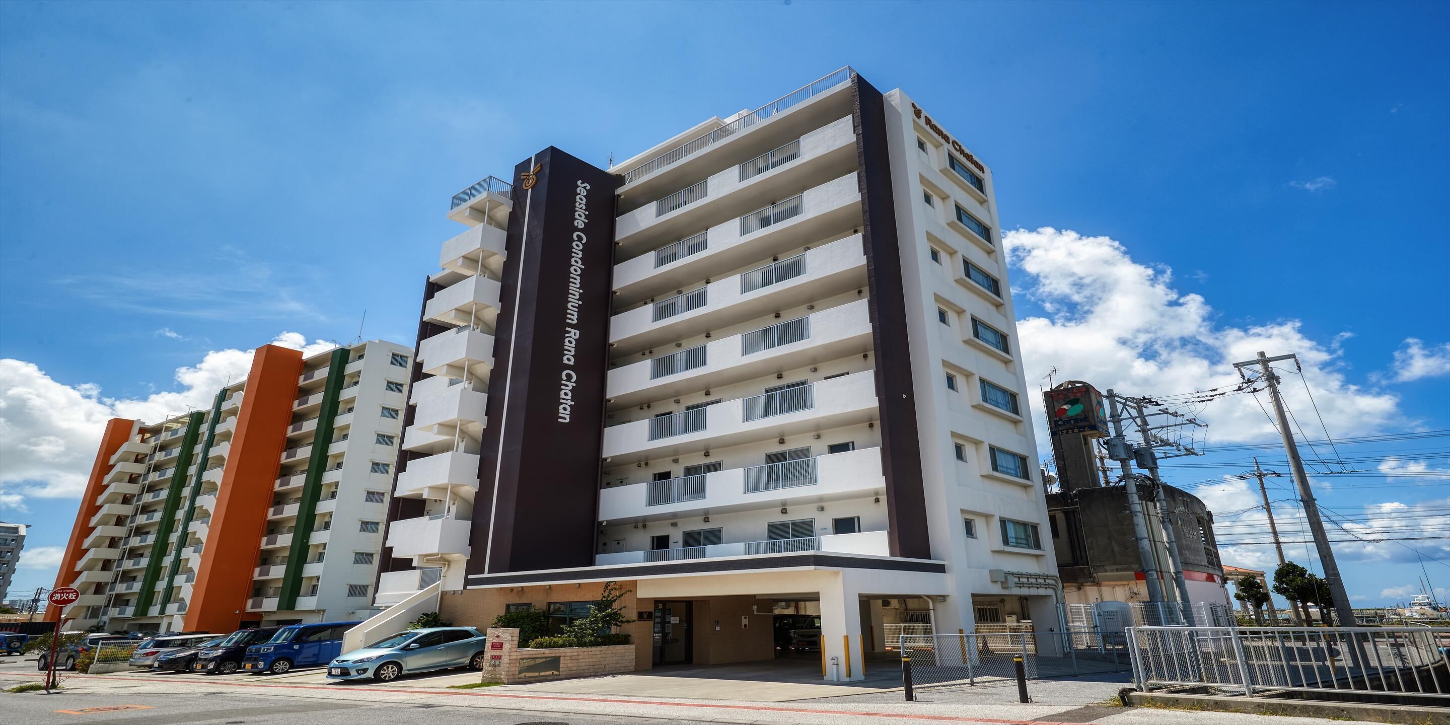 Um edifício de vários andares com uma placa vertical chamativa que diz "Janesville Condominium Park Chanot".