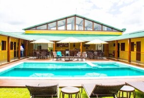 Piscina externa, guarda-sóis, espreguiçadeiras
