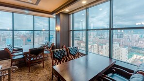 Quarto de hotel moderno em um arranha-céu, com uma grande janela e vista para a cidade.