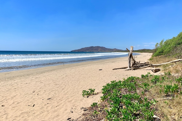 Na praia, areia branca, toalhas de praia, Prática de surfe/bodyboard