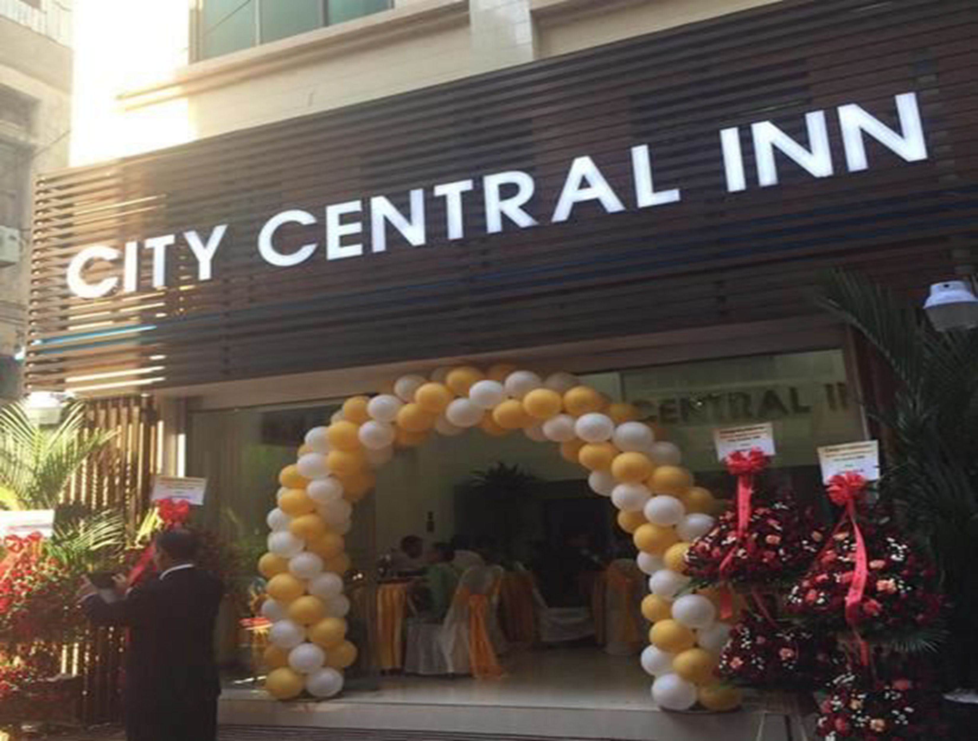 Exterior do City Central Inn com uma grande placa sobre a entrada.