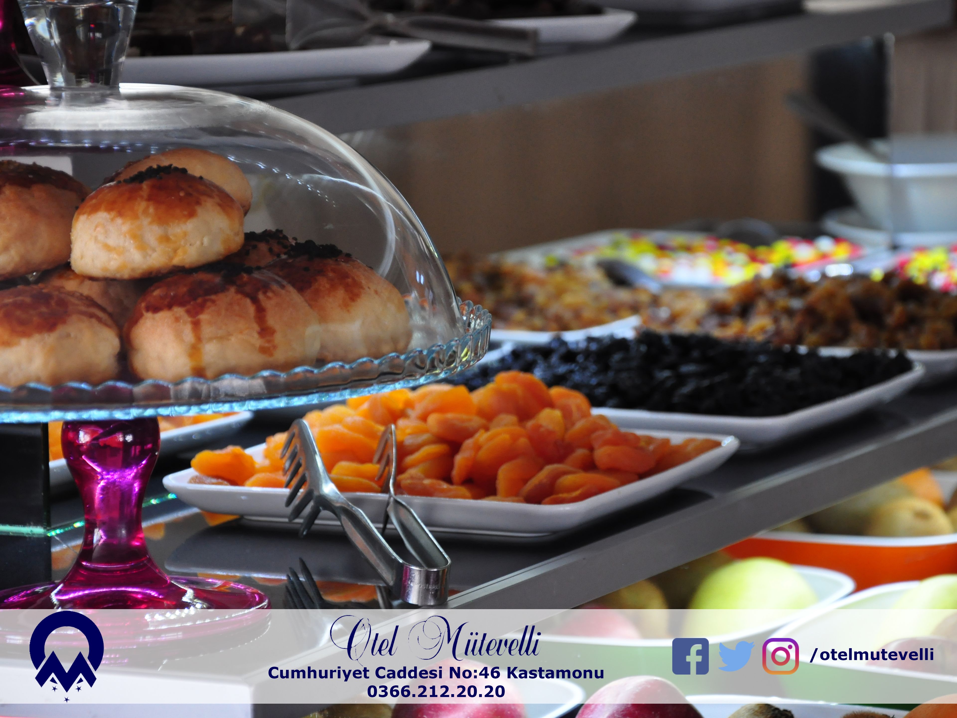 Buffet variado com diversos alimentos, incluindo doces e frutas, e um expositor de vidro.