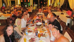 Restaurante com várias mesas e clientes sentados.