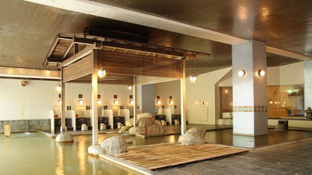 Uma onsen japonesa tradicional com um deck de madeira, assentos de pedra e interior revestido de azulejos.